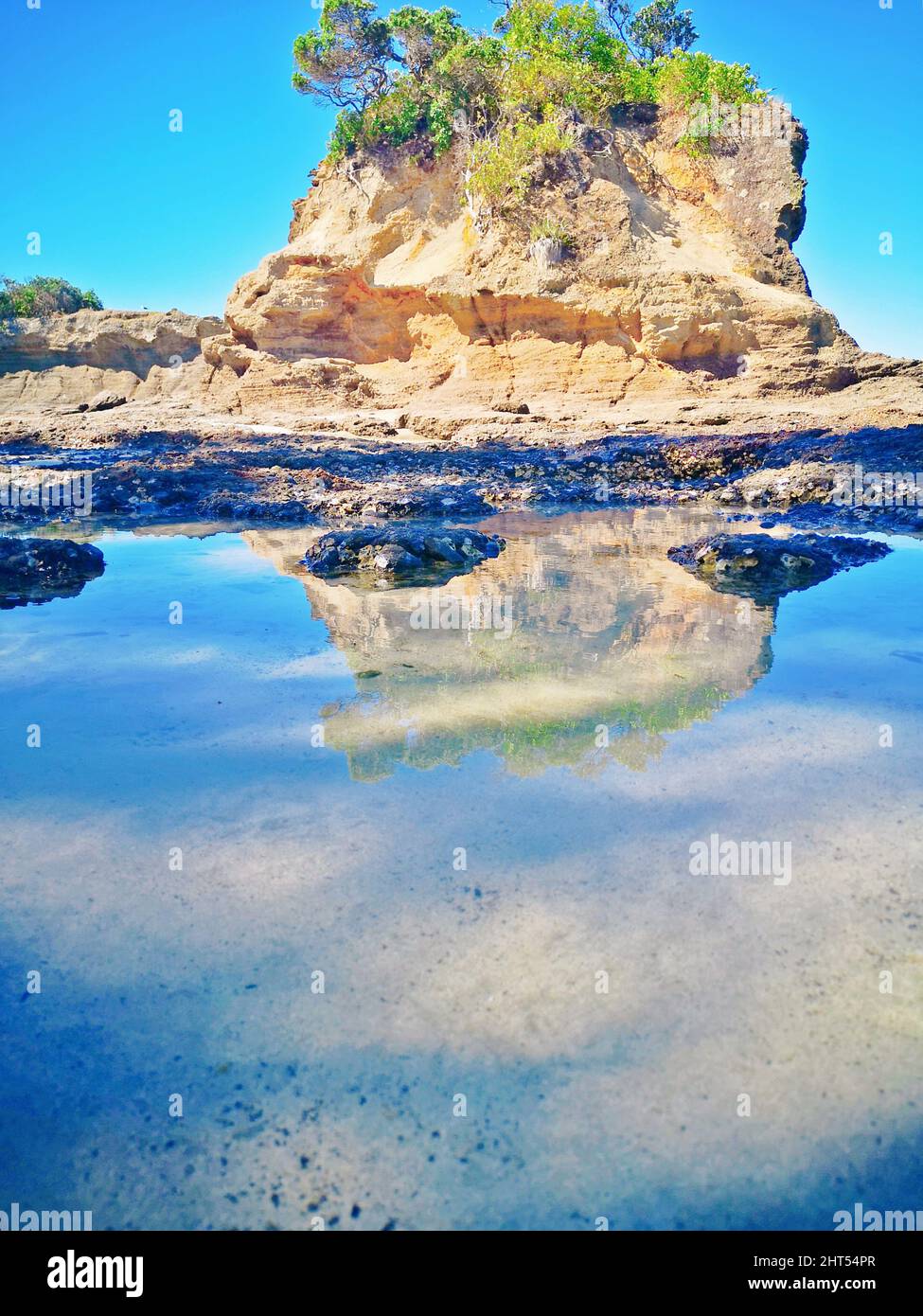 Low angle vertical shot of a cliff reflection in the water in Anchor ...