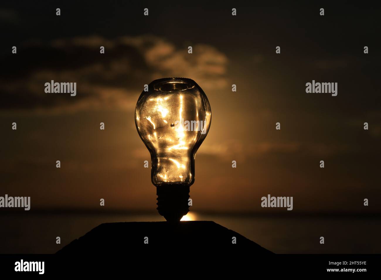 Reflective glass lightbulb against a golden sunset background Stock ...