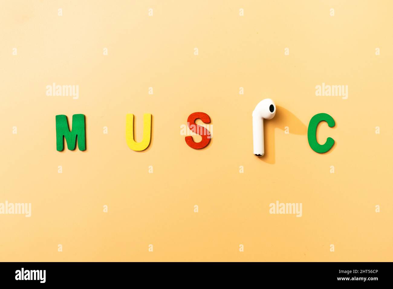 The Word Music On Wooden Color Letters With A Wireless Earphone the-word-music-on-wooden-color-letters-with-a-wireless-earphone