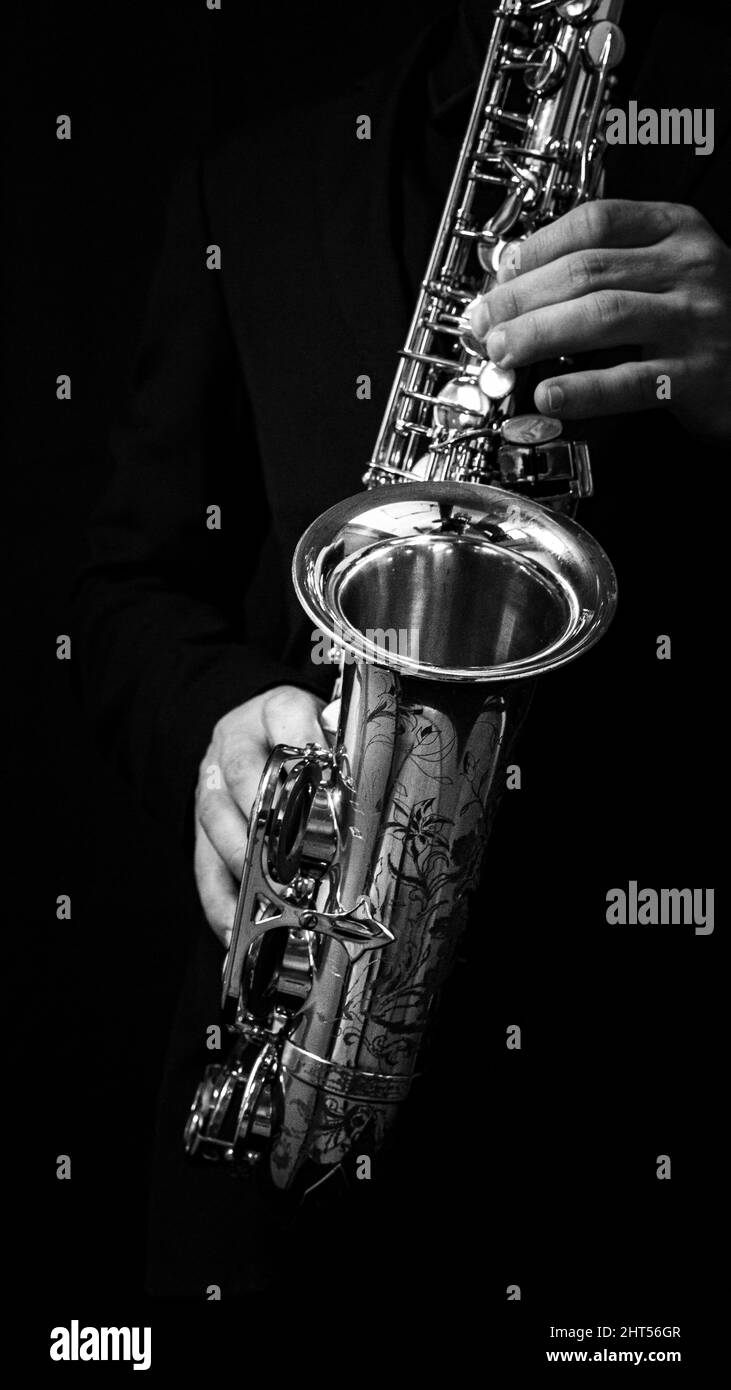 Grayscale of a man's hand playing a saxophone Stock Photo - Alamy