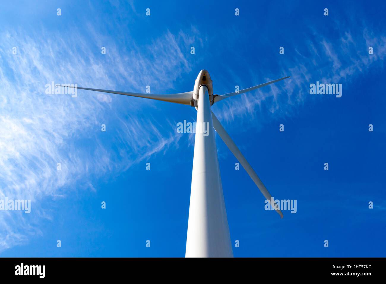 Wind turbine pylon from bottom against blue sky with clouds Stock Photo ...