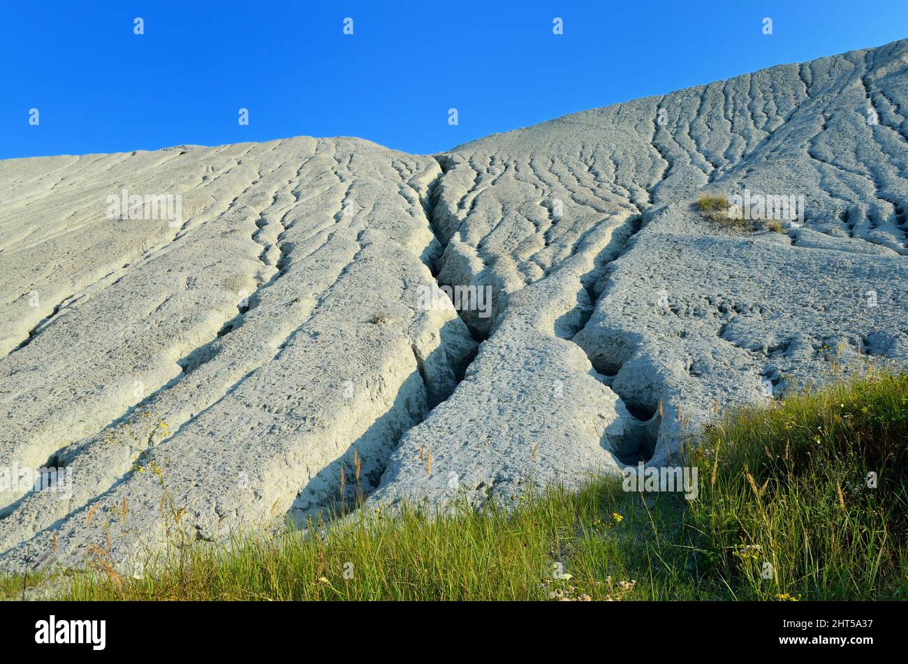 Landscape of dried mud texture against a blue sky Stock Photo - Alamy