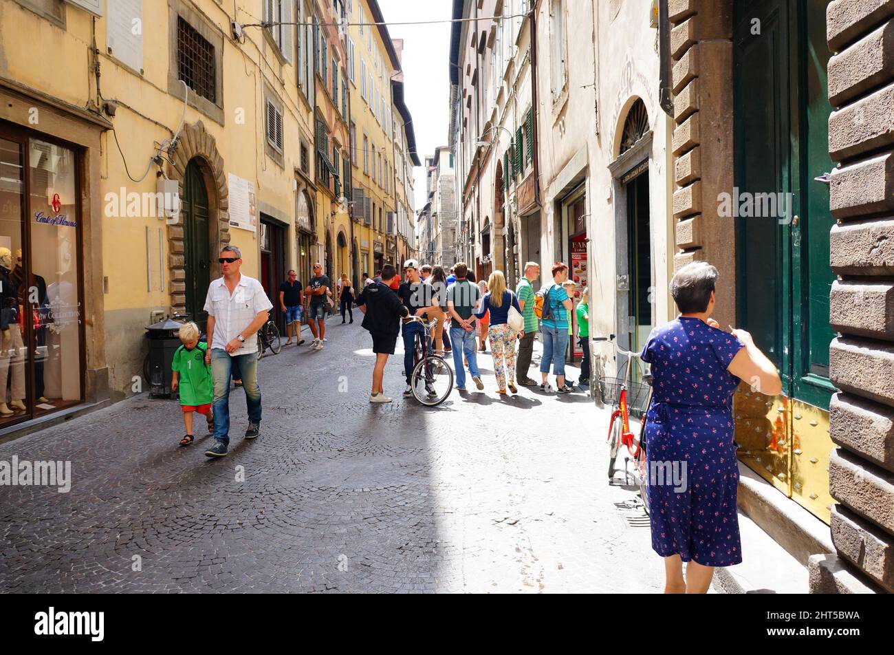 Group of people walking through narrow street in Italy, Lucca Stock ...