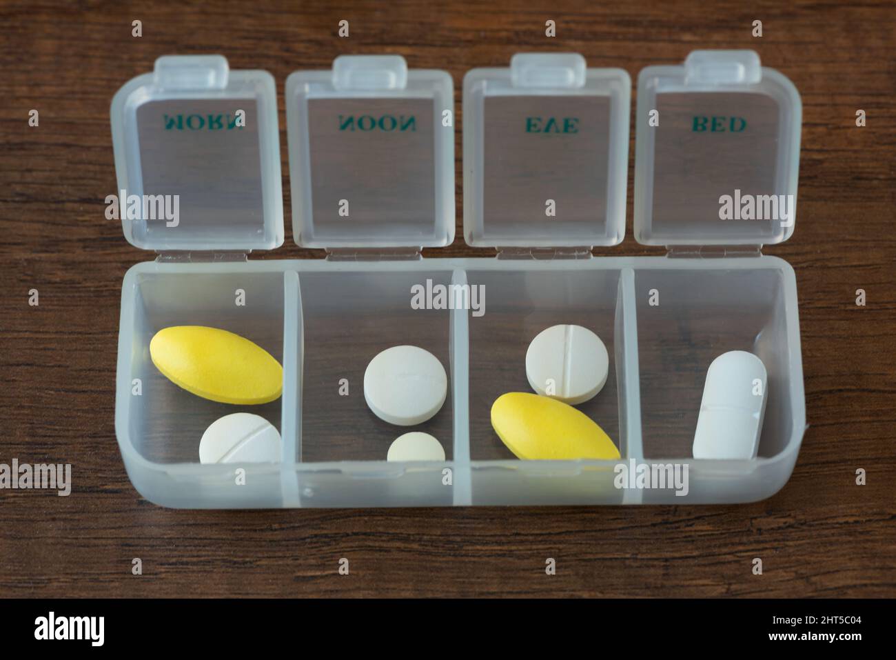 Medications in open plastic container dividing according to the time of ...