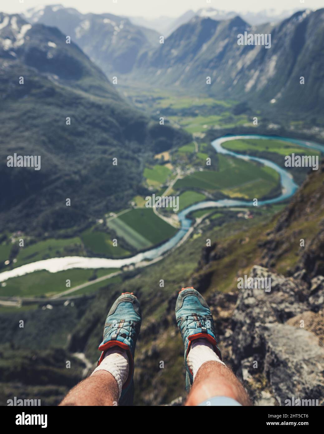 Vertical view of a mountain climber's feet hanging from the rock on the ...