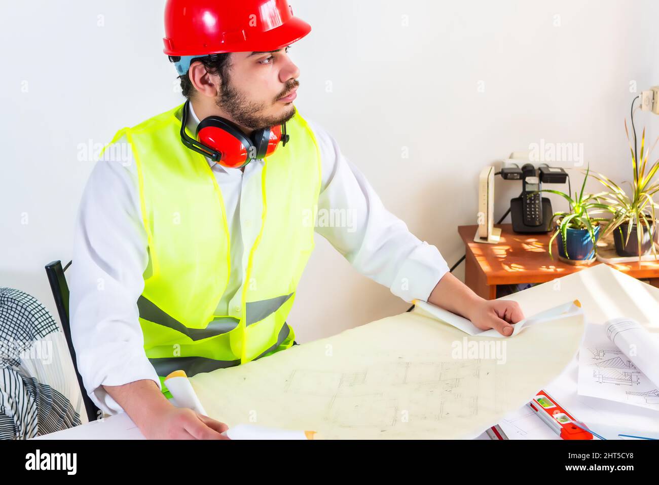 Builder or contractor checking blueprint on the desk Stock Photo - Alamy
