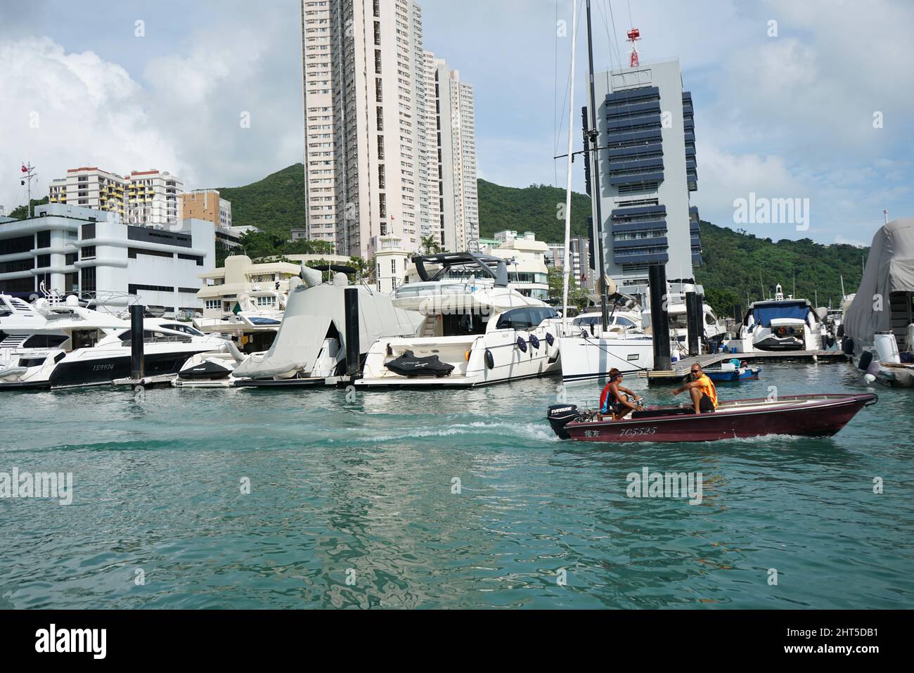 Water front with boats and a small boat passing by in Hong Kong Stock ...