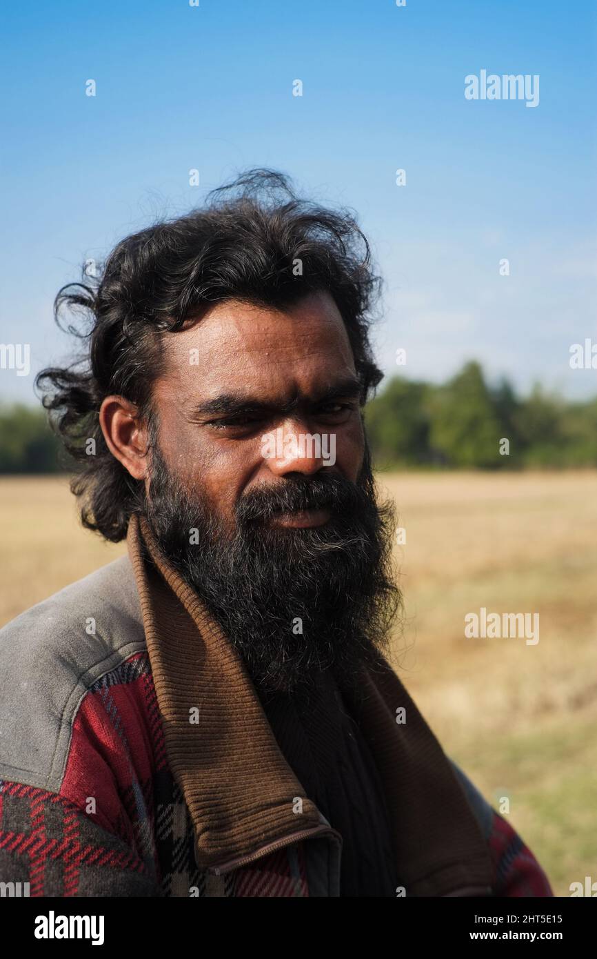 Baul bearded gypsy man portrait in sunlight against blue sky and a ...