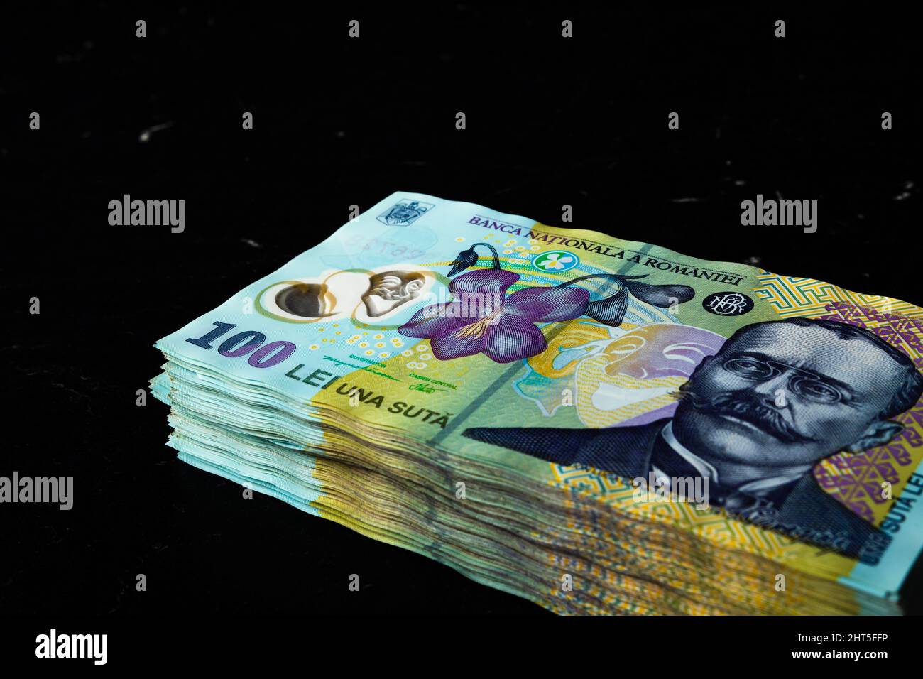 Closeup shot of a 100 leu banknotes stack isolated on black background ...