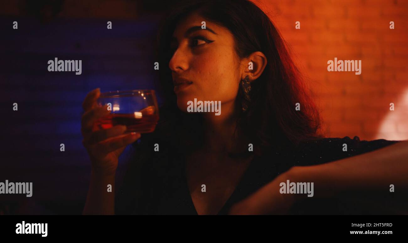 Portrait of a female drinking at a night club Stock Photo - Alamy