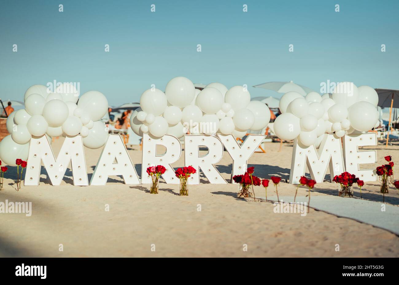 Sign of Marry me in big letters with roses on a beach Stock Photo - Alamy