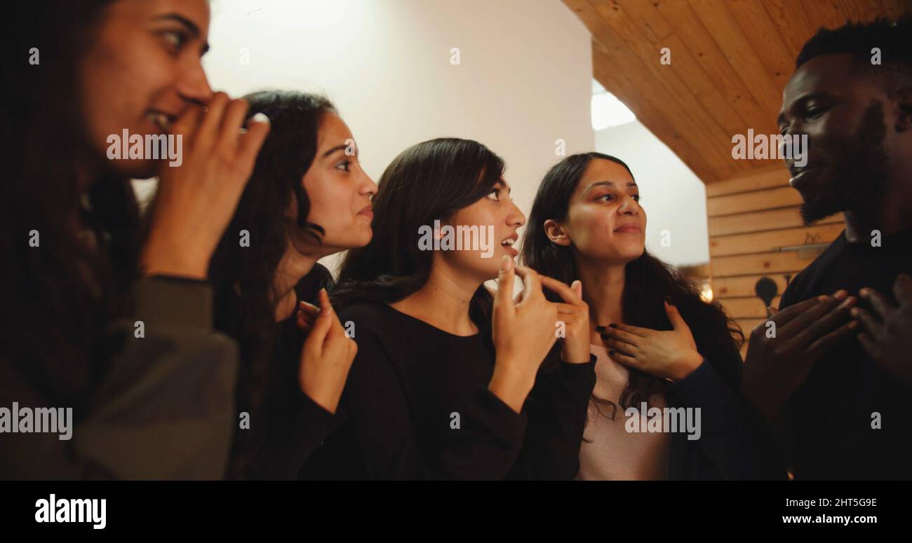 Group of young South Asian friends talking and smiling indoors in India ...