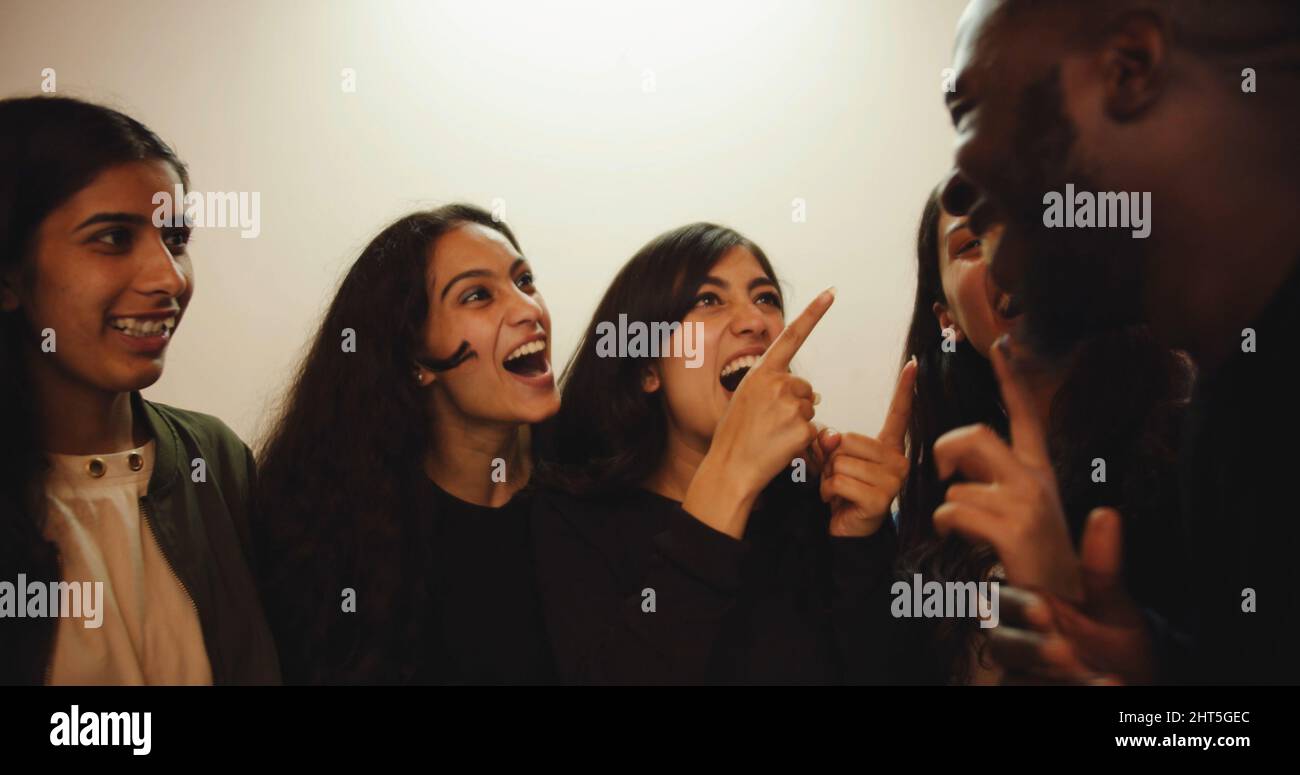 Group of young South Asian friends talking and laughing indoors in ...