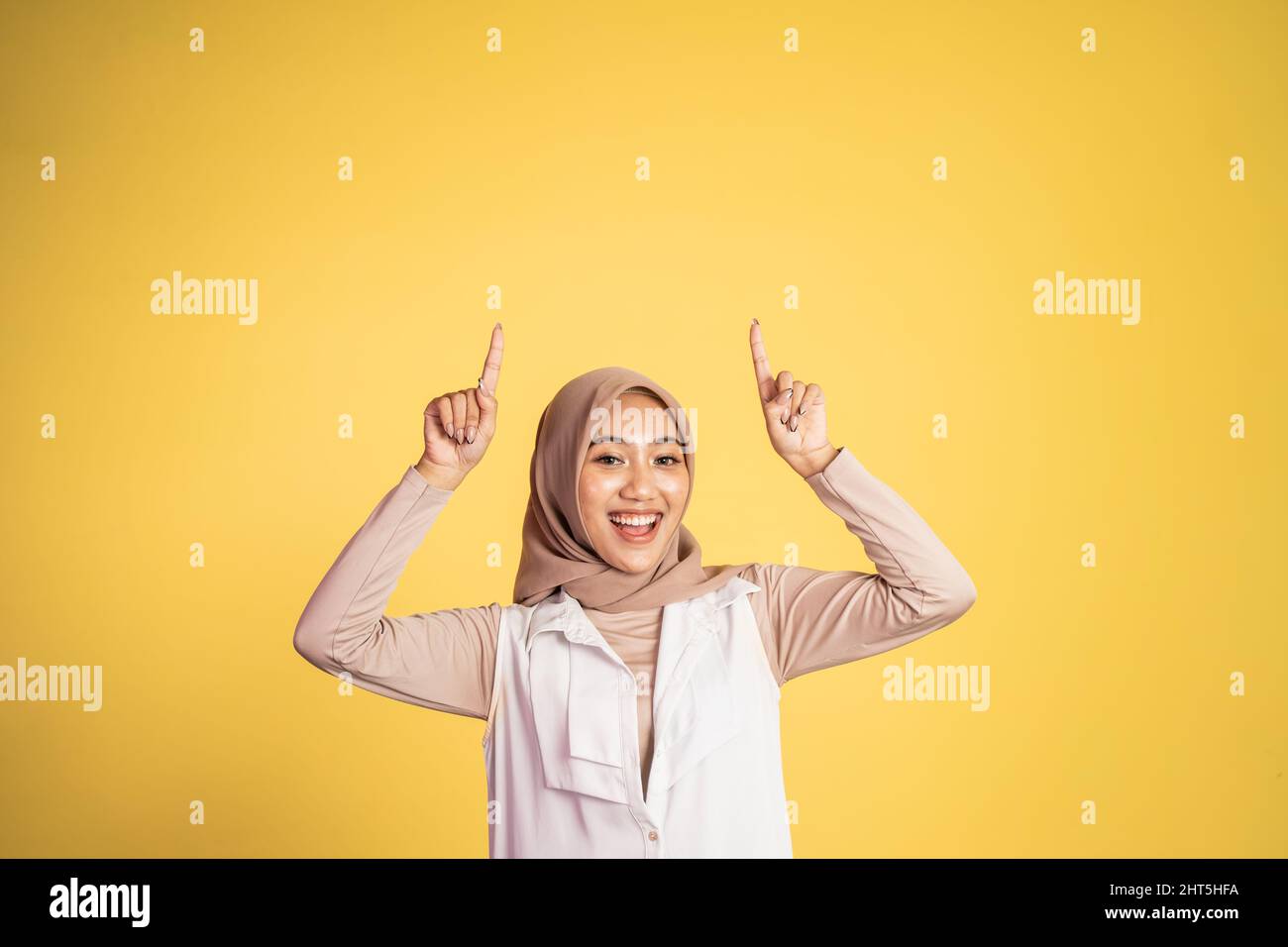 Smiling hijab woman with finger pointing up hand gesture Stock Photo ...