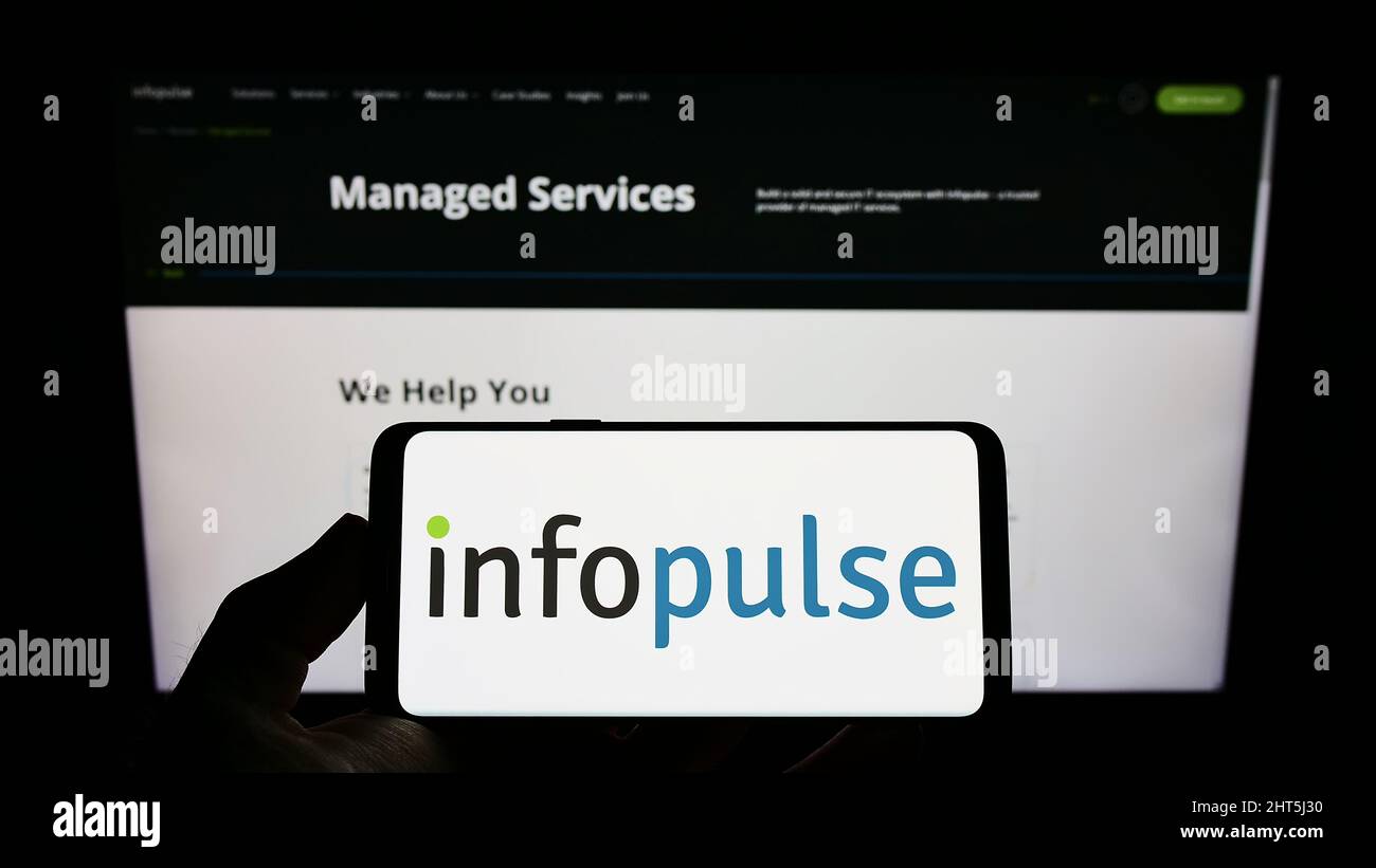 Person holding mobile phone with logo of IT services company Infopulse ...