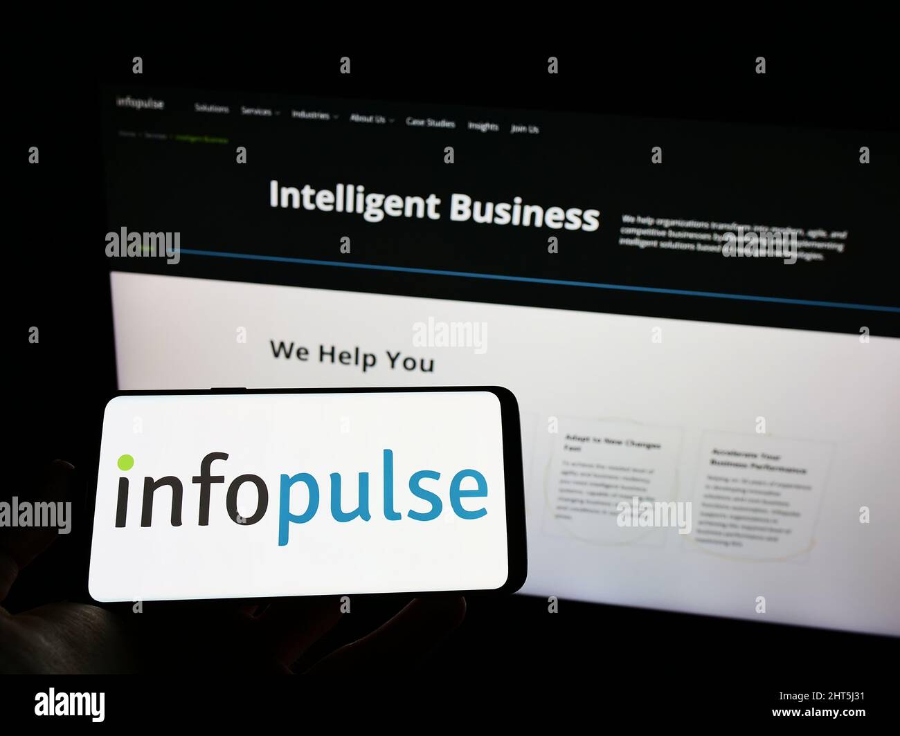 Person holding cellphone with logo of IT services company Infopulse ...