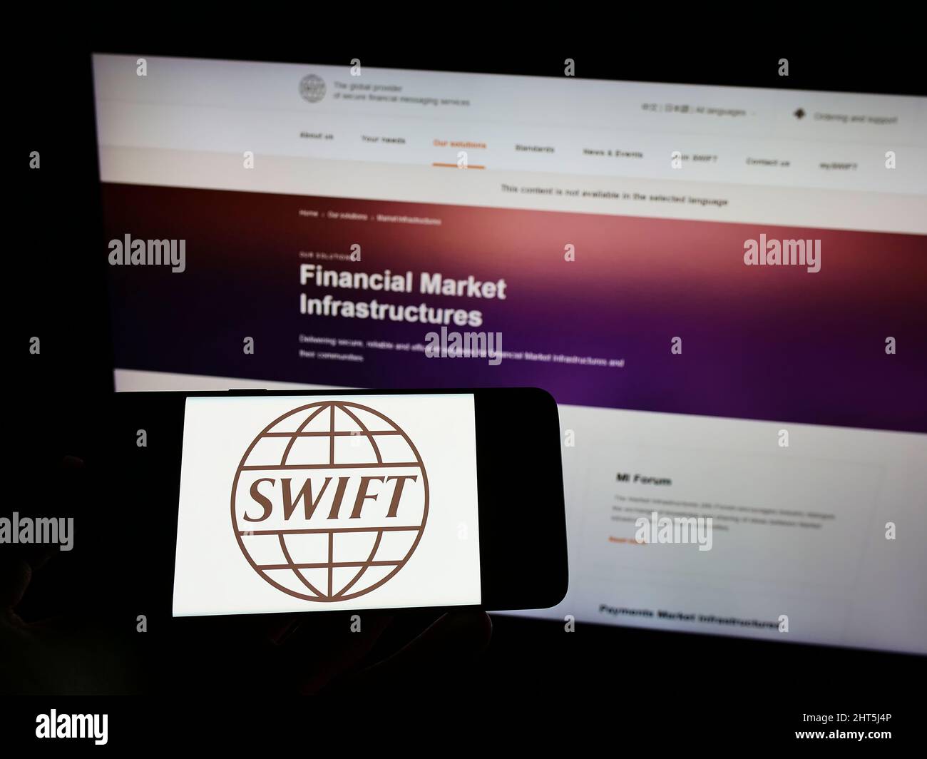 Person holding smartphone with logo of banking transaction system SWIFT ...