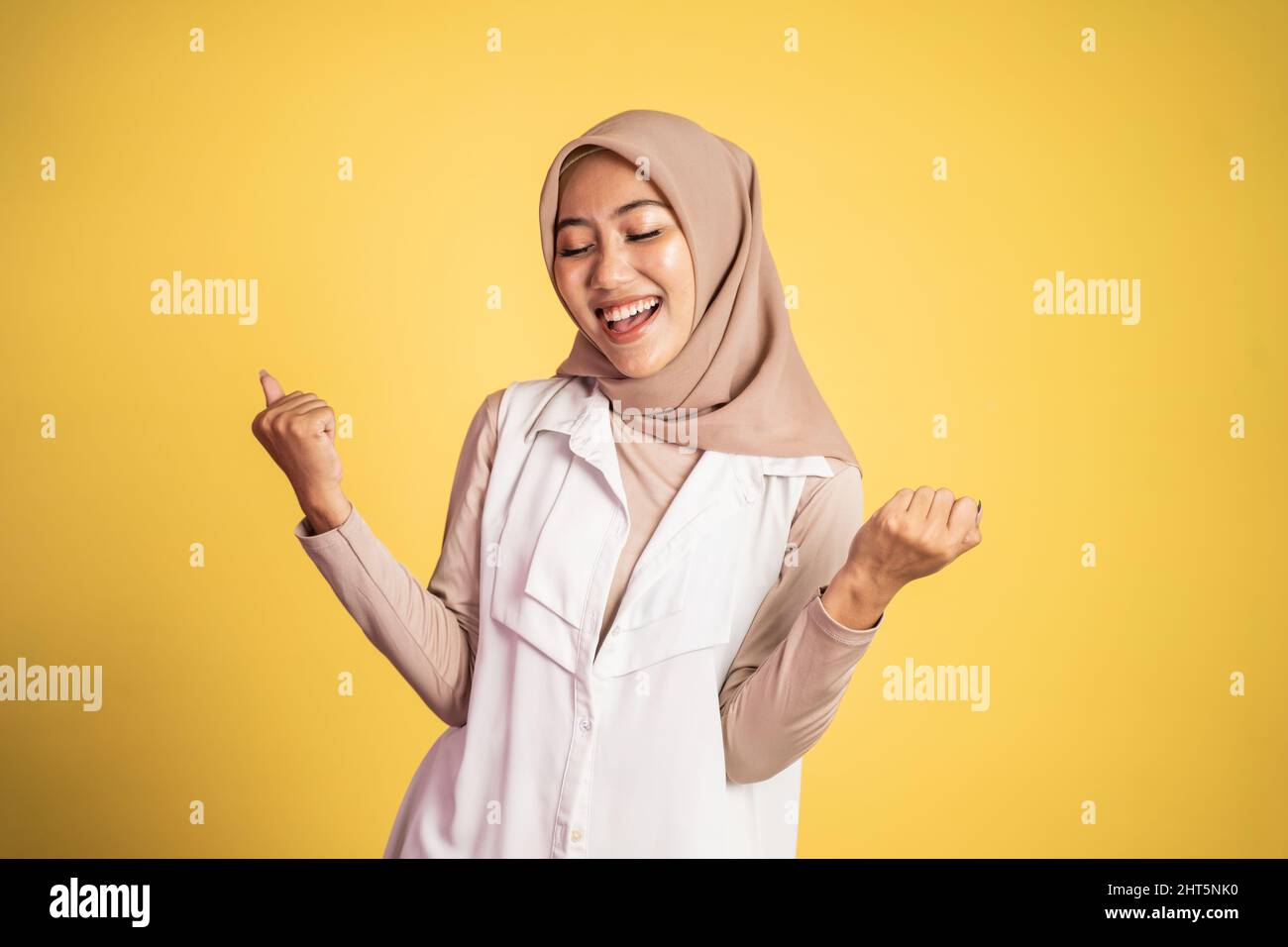 woman in hijab clenching hands while celebrating success Stock Photo ...