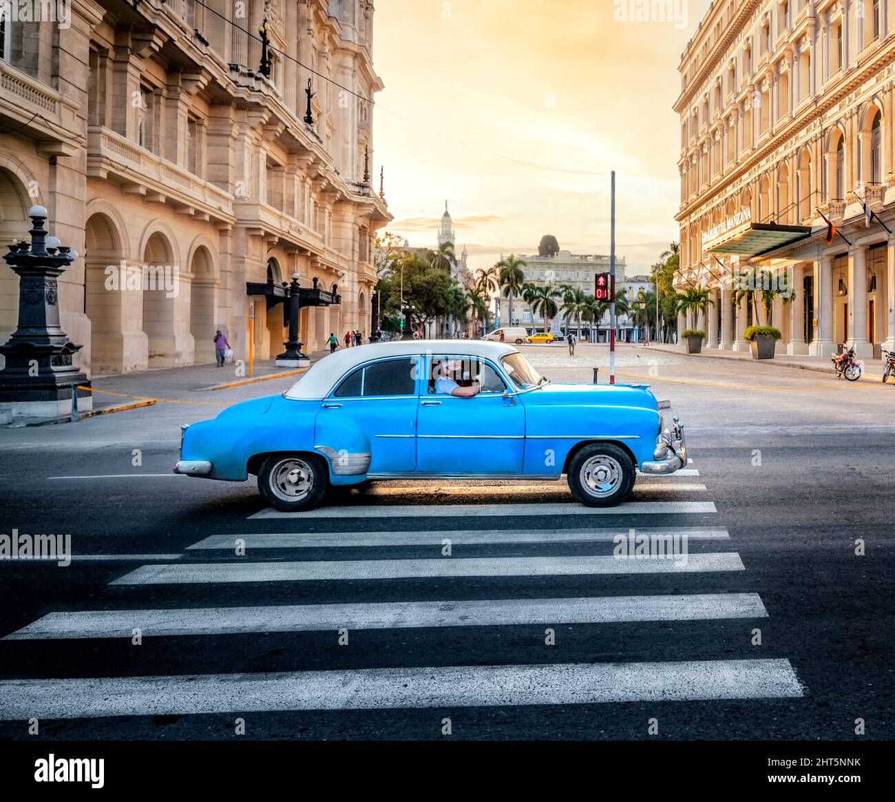 Car going through a crosswalk with a sunset sky on the background ...