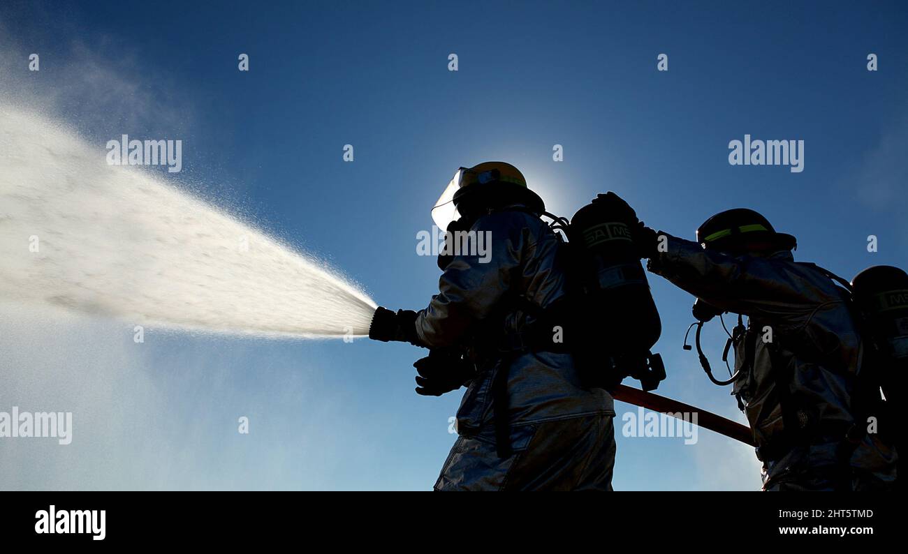 Firefighters trying to put out a fire Stock Photo - Alamy