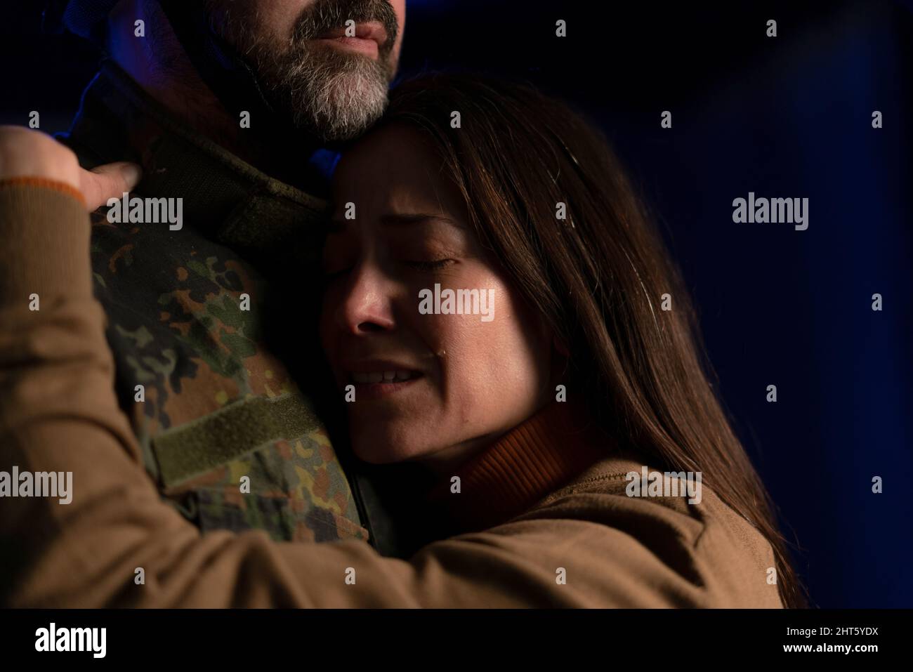 Sad woman crying when hugging her military husband and saying-goodby to ...