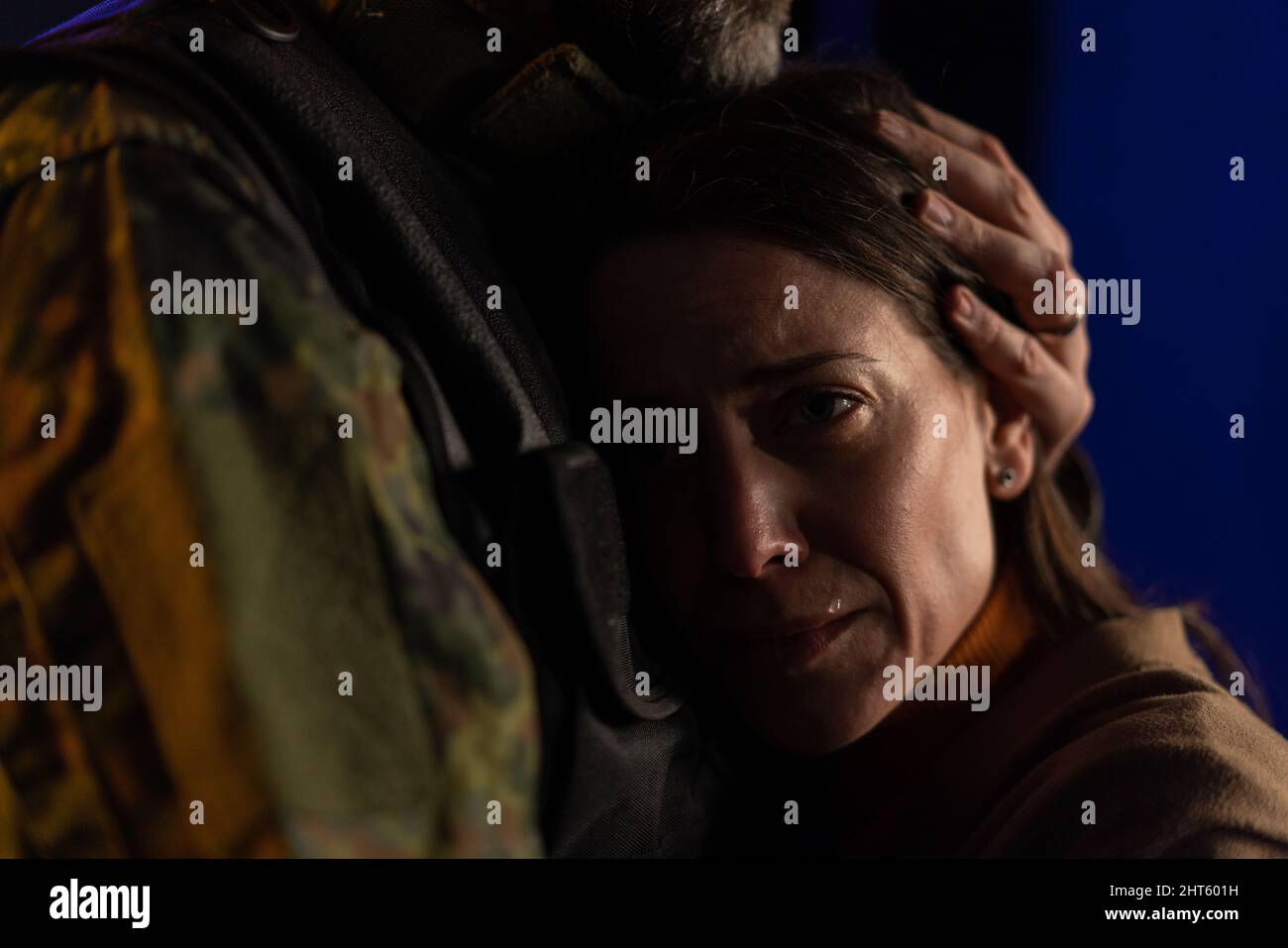 Close-up of sad woman crying when hugging her military husband and ...
