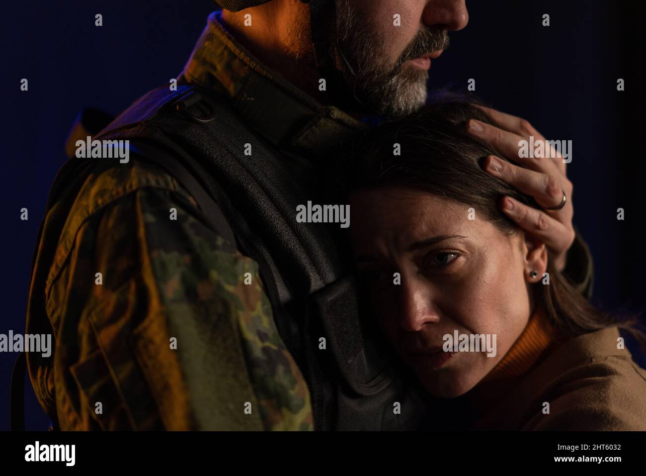 Close-up of sad woman crying when hugging her military husband and ...