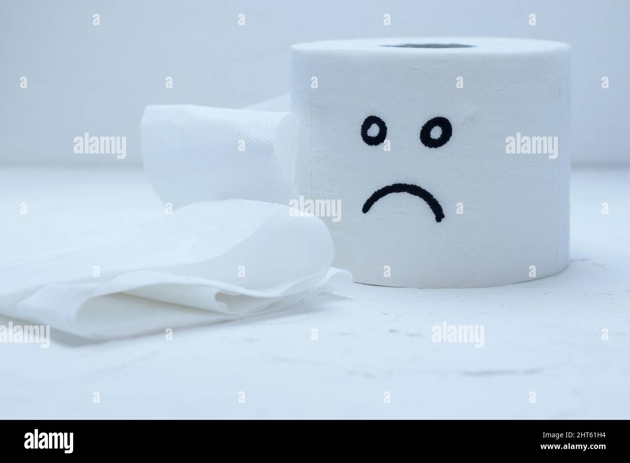 Toilet paper with a sad smiley drawing Stock Photo - Alamy