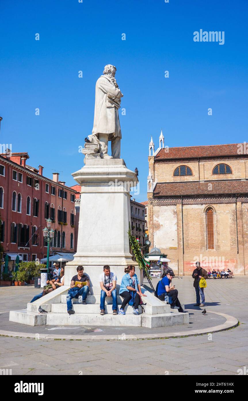 Vertical shot of tourists sitting by a historical statue at a Campo ...