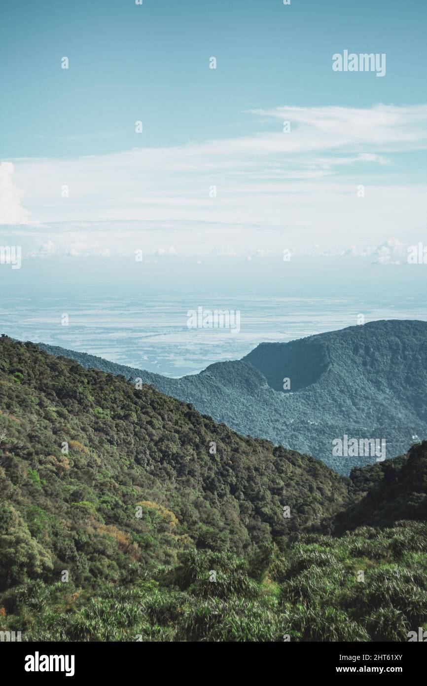 Vertical view of the beautiful mountains with forests and the cloudy ...