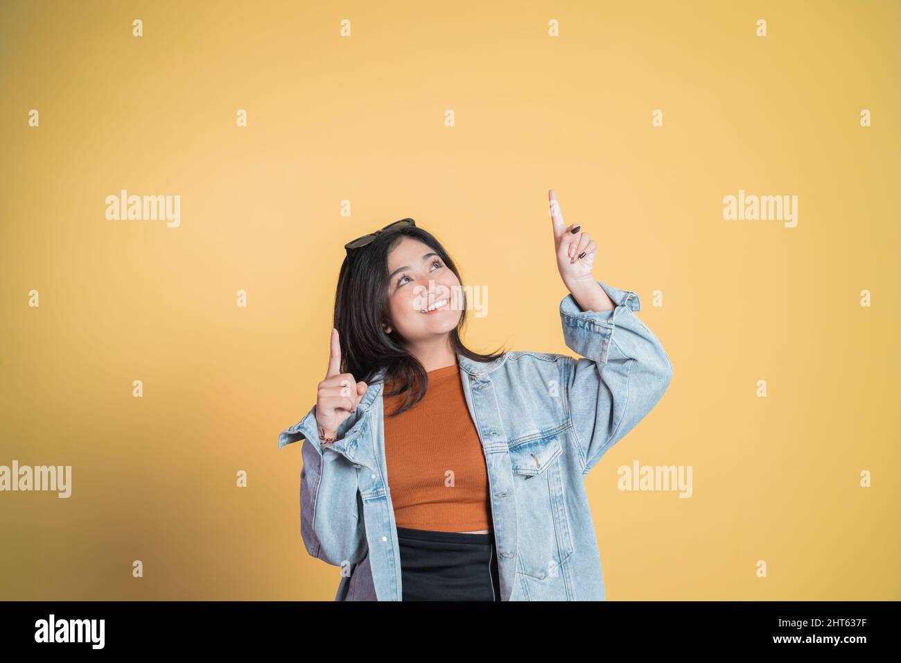young woman with two finger pointing up Stock Photo - Alamy