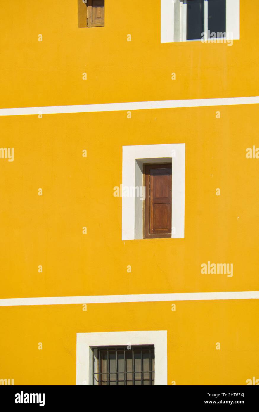 Vertical view of a yellow facade of a colonial building with wooden ...