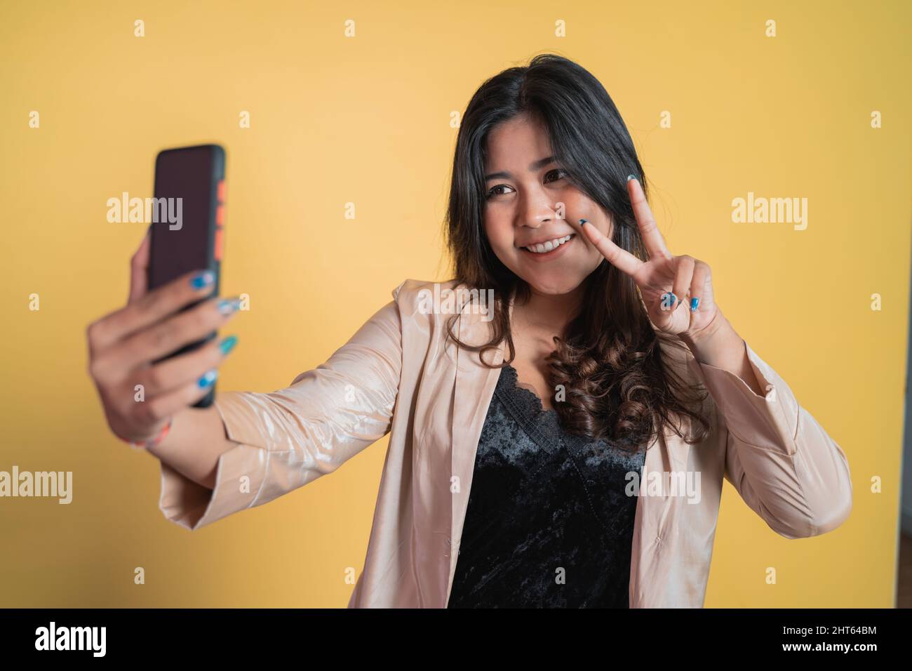 young woman take a selfie with v sign finger gesture Stock Photo - Alamy