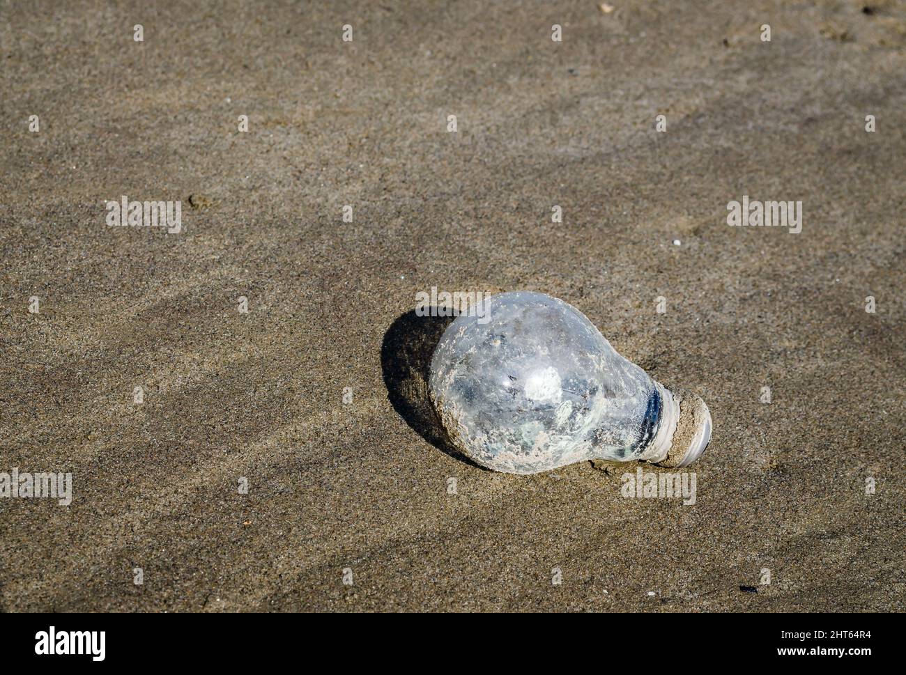 A discarded glass bulb smeared with sand on the banks of the Danube ...
