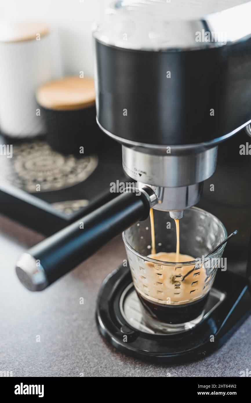 coffee machine pouring double espresso shot in clear coffee glass ...