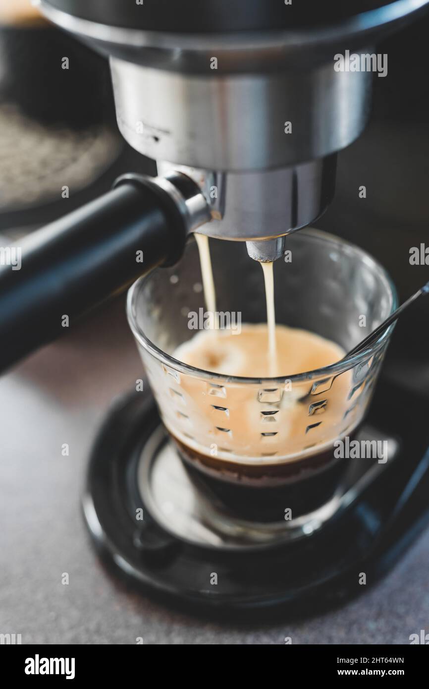 coffee machine pouring double espresso shot in clear coffee glass ...