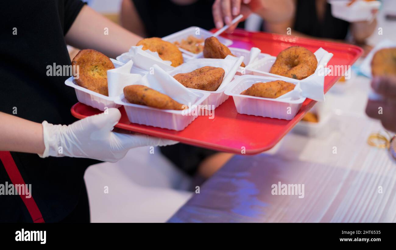 Selective of hands serving fast food on a red plate Stock Photo - Alamy