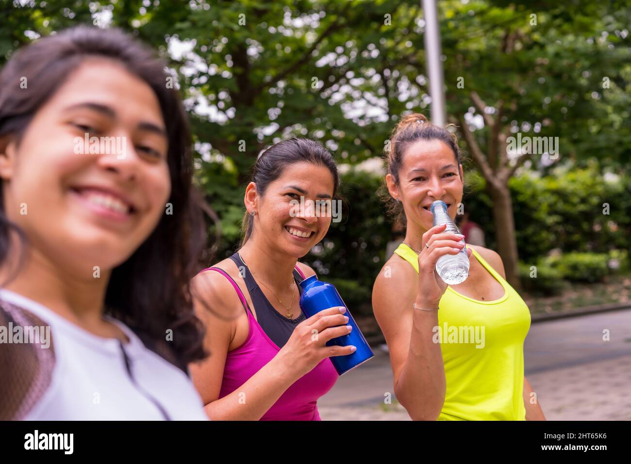 A group of friends smiling and drinking water in a park Stock Photo - Alamy