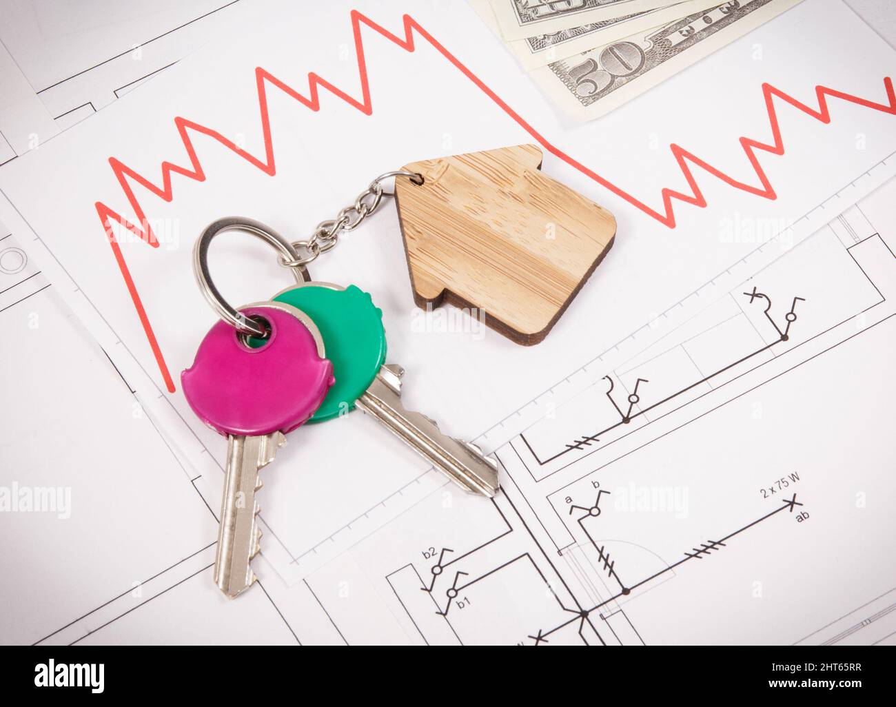 Keys with home shape, currencies dollars and downward graphs on ...