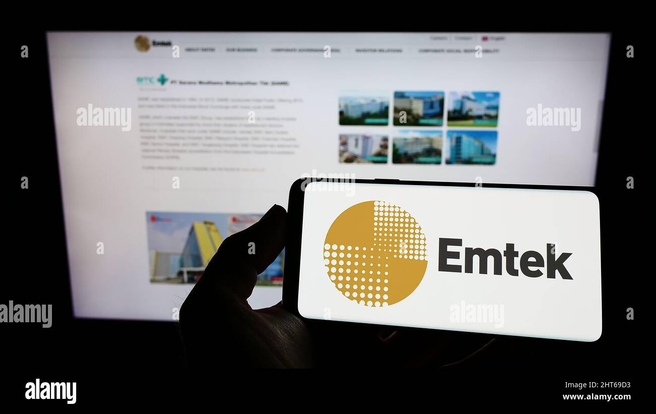 Person holding cellphone with logo of company PT Elang Mahkota ...