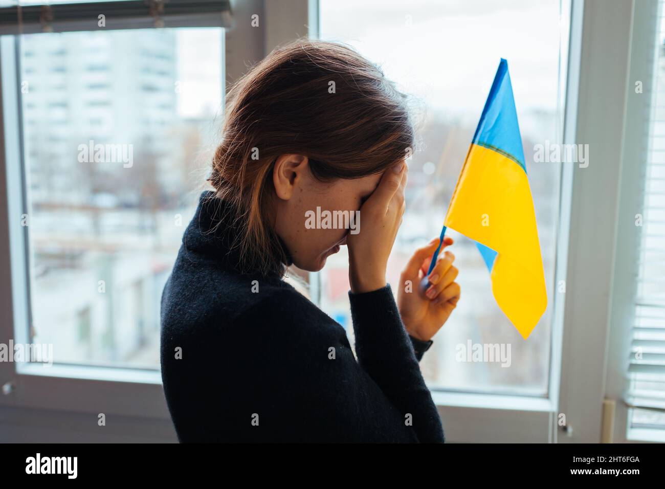 Crying sad woman in grief holding Ukrainian flag during war with Russia ...