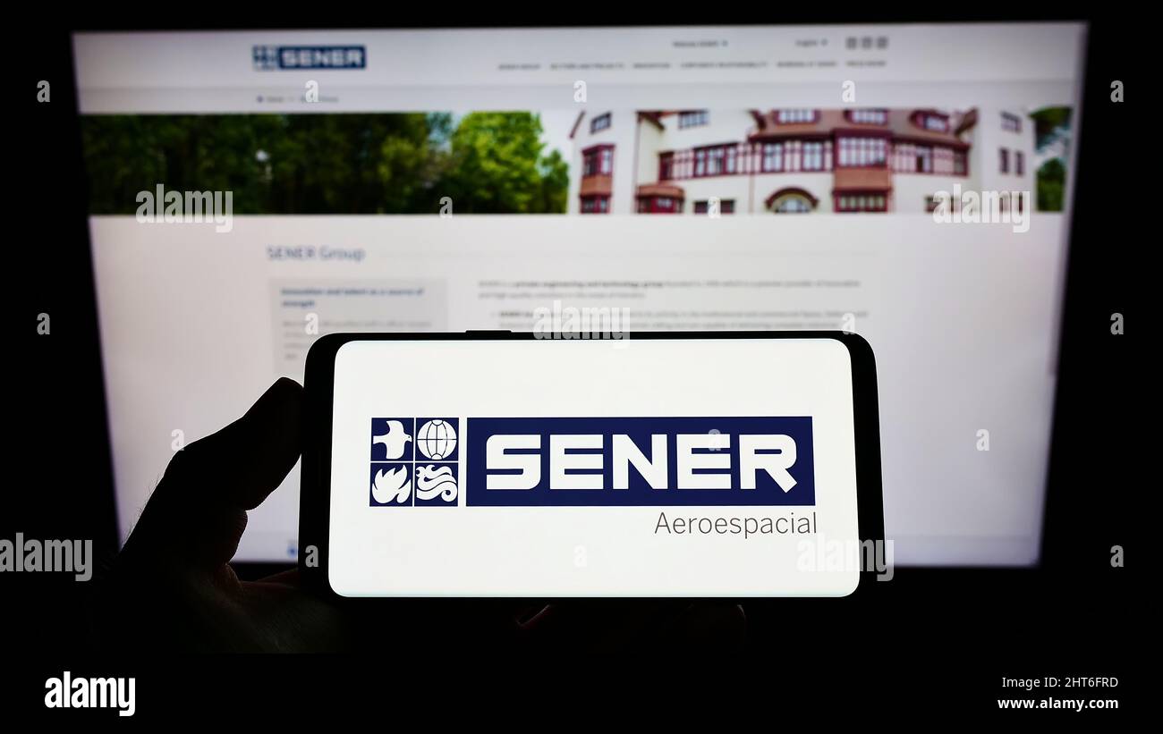 Person holding smartphone with logo of Spanish company SENER Grupo de ...