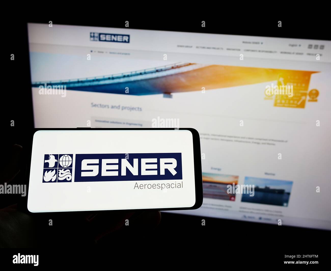 Person holding mobile phone with logo of Spanish company SENER Grupo de ...