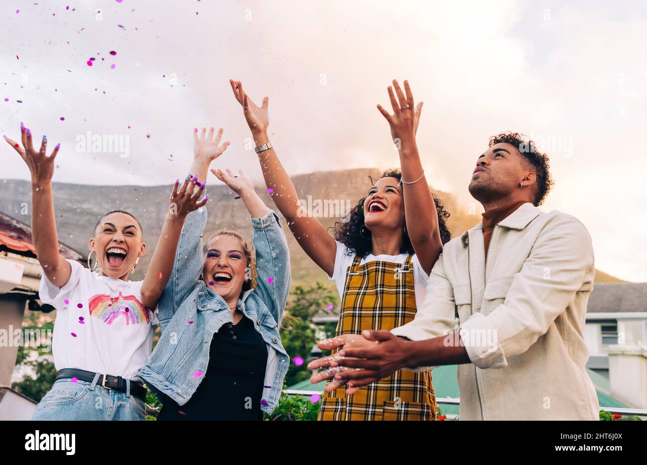 Multicultural friends enjoying a party on a rooftop. Group of vibrant ...