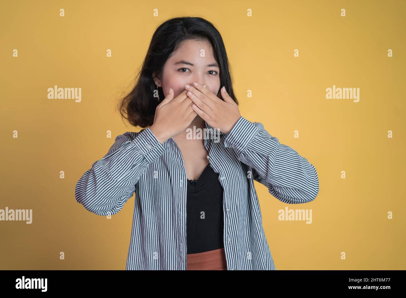 Young woman with shocked expression with hands covering mouth Stock ...