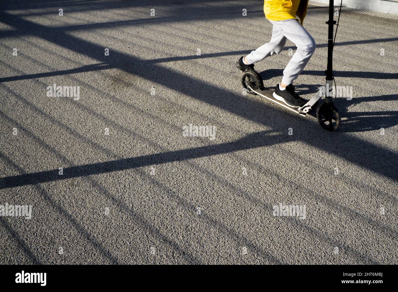 Asphalt road with shadows and scooter Stock Photo - Alamy