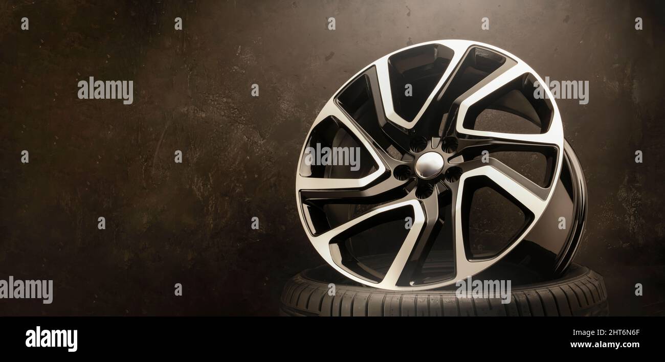 new stylish cool alloy wheel on the tire dark textured background ...