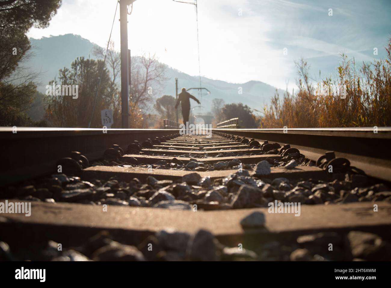 Rails of a train railway in perspective view and a person walking on ...