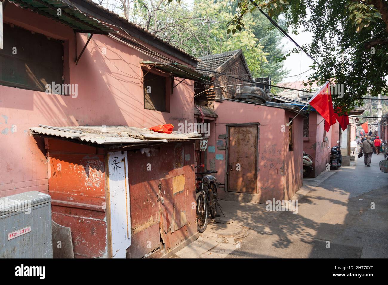 Typical residential alleyway (hutong) in Beijing, with Chinese flags ...