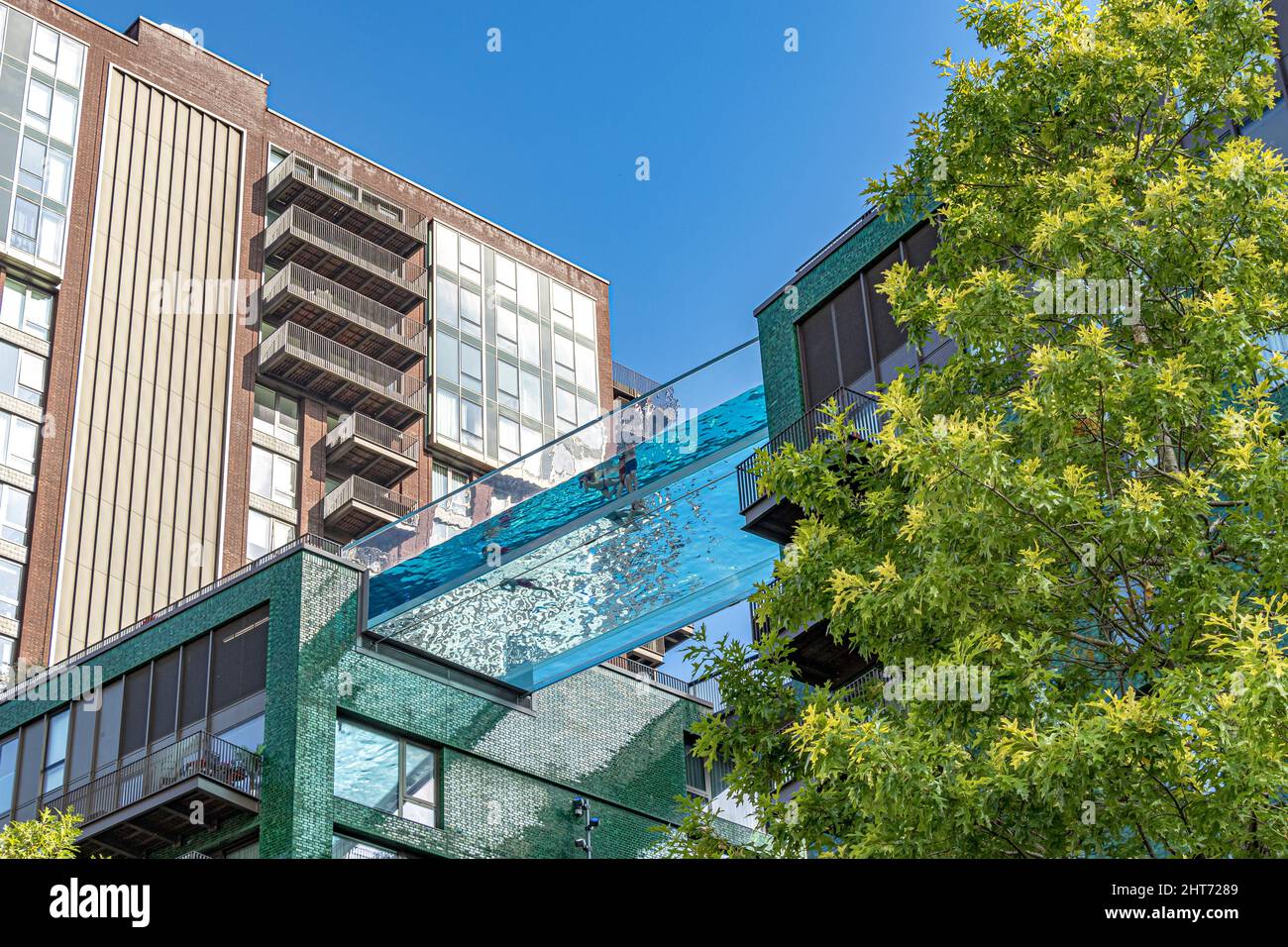 People swimming in The Sky pool, which stretches between two luxury ...